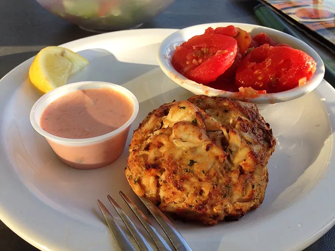 The star of the show in its natural habitat—a golden-brown crab cake that's more crab than cake, served with a side of Florida sunshine.