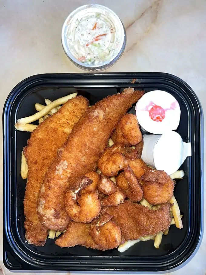 Golden-brown perfection on a plate. This fish and shrimp combo isn't just lunch – it's a crispy, crunchy masterpiece worth crossing town for.