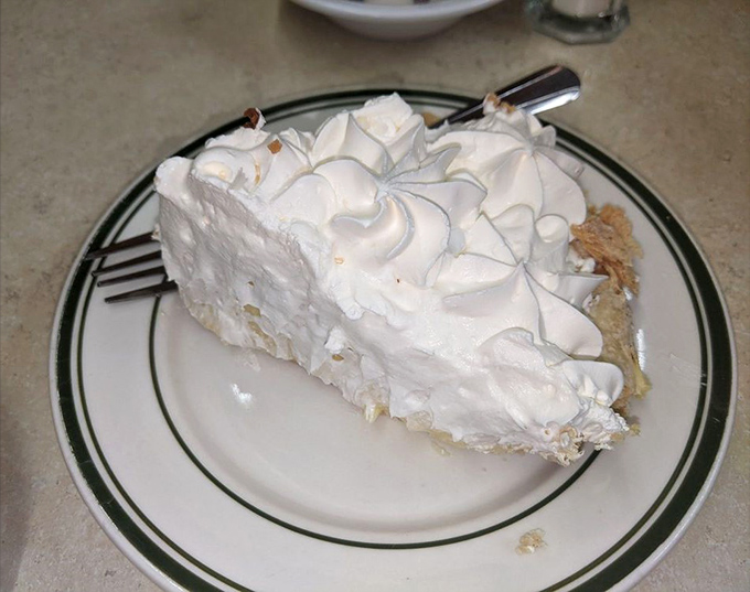 That's not just a slice of coconut cream pie—it's a cloud that somehow landed on a plate, with meringue peaks that would make the Himalayas jealous.