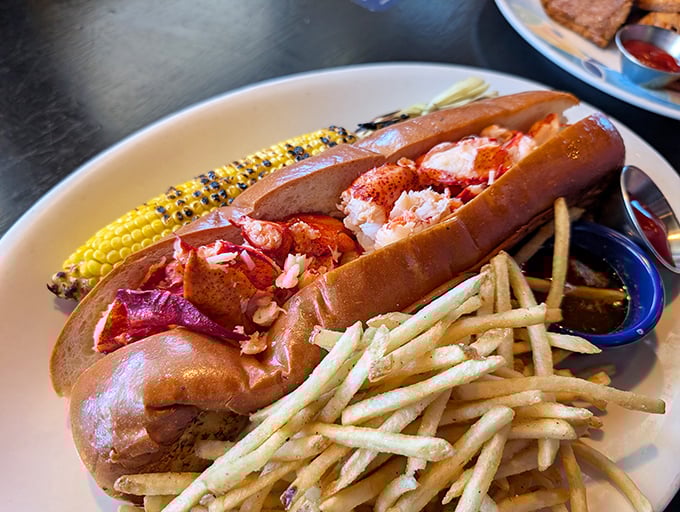 The lobster roll arrives like a celebrity on a plate – chunky lobster meat taking center stage while corn and fries play worthy supporting roles.