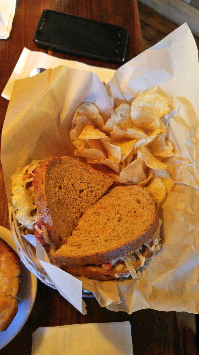 This isn't just a Reuben; it's a masterclass in sandwich architecture, served with house-made chips and a pickle spear for good measure.