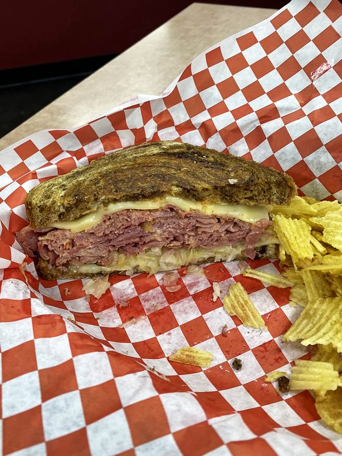The Reuben reveals itself in cross-section glory—architectural perfection where corned beef meets sauerkraut in holy matrimony.