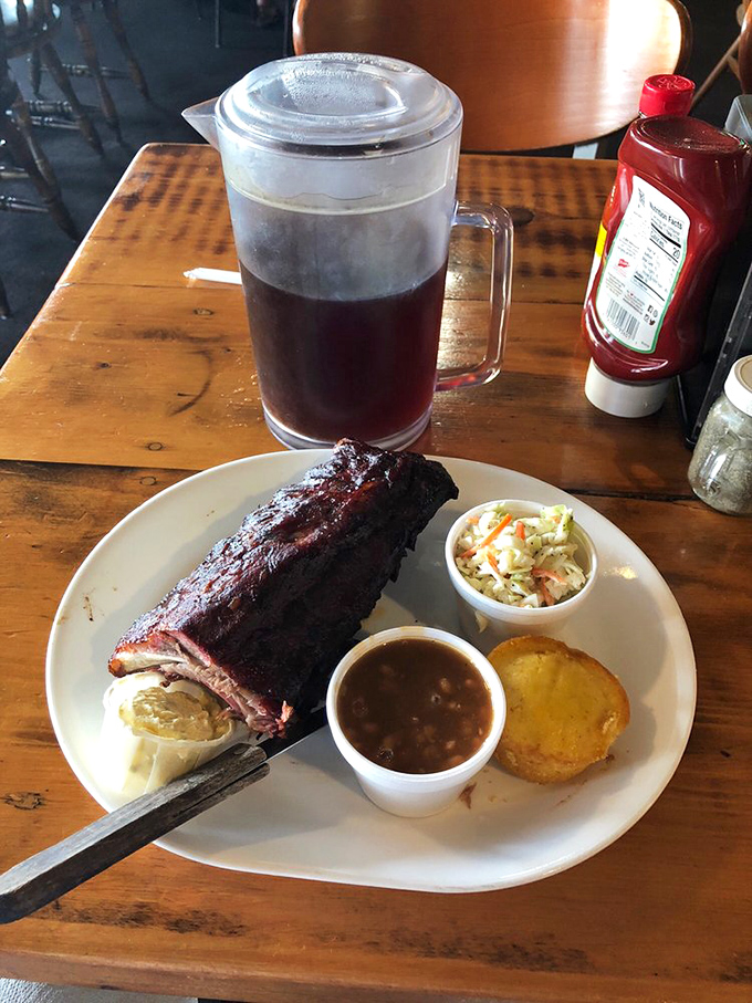 Behold the holy trinity of barbecue perfection: fork-tender ribs with that coveted smoke ring, homemade sides, and a cold drink to wash it all down.