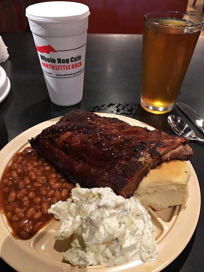 Barbecue nirvana on a plate—glistening ribs with that perfect bark, creamy potato salad, and beans that have clearly been simmering since dawn.