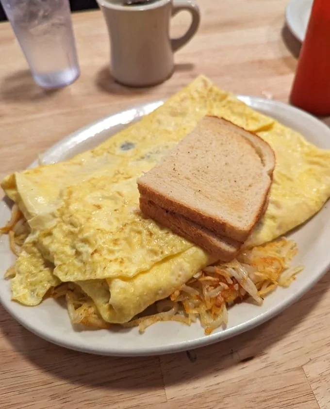 A classic diner breakfast that doesn't need fancy tricks – just eggs folded to perfection, crispy hashbrowns, and toast that's ready for its supporting role.