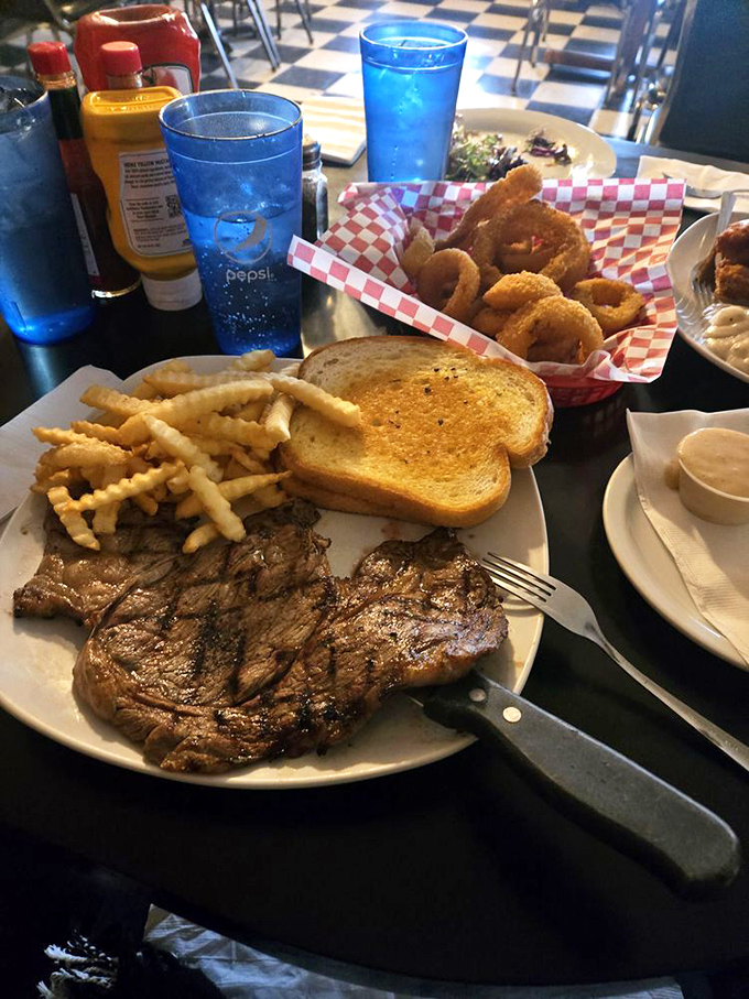 Steak that doesn't need Instagram filters—just blue Pepsi glasses and golden onion rings. This is what dinner looked like before we all became food photographers.