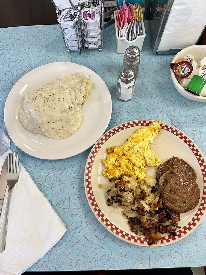 Two worlds collide on this plate—country-style gravy blankets one dish while eggs, hash browns, and sausage create a trifecta of breakfast perfection on the other.