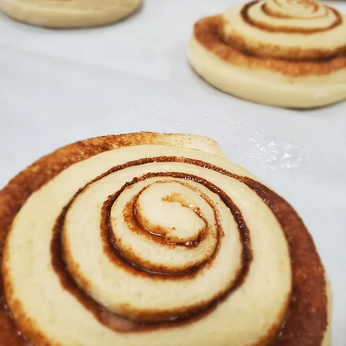 These aren't just cinnamon rolls—they're spiral-shaped happiness, the kind that makes you close your eyes and momentarily forget your own name.