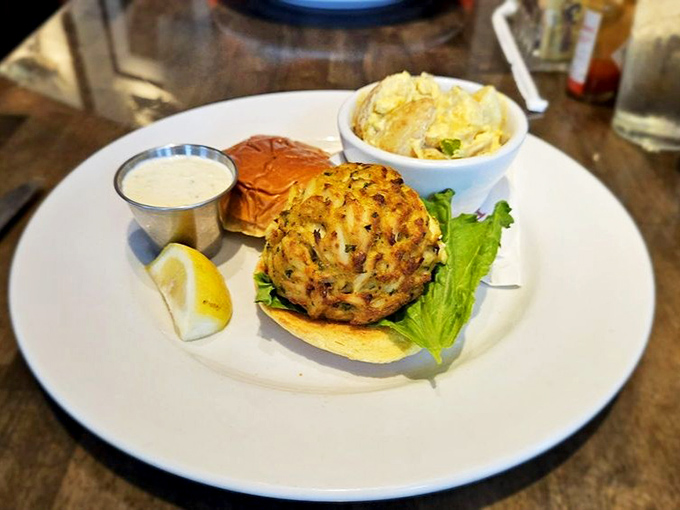Behold the holy grail of Maryland cuisine: a golden-brown crab cake that's more treasure than sandwich, accompanied by its faithful sidekick—house-made tartar sauce.
