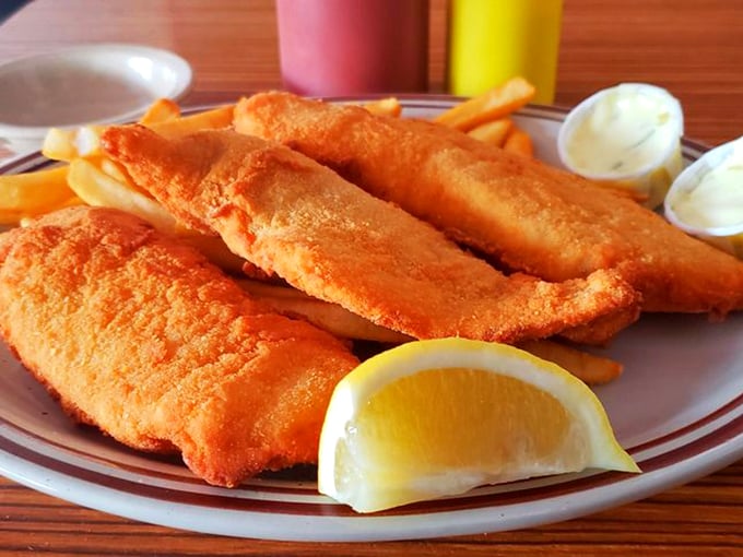 Golden-battered fish fillets that shatter with each bite, revealing flaky white perfection within. The lemon wedge isn't just garnish—it's essential equipment.