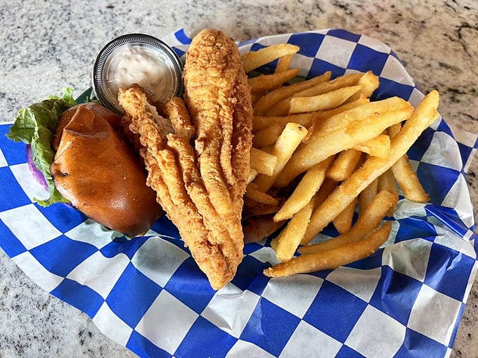 The star of the show arrives! Crispy flounder nestled in a soft bun with just enough fries to make your cardiologist nervously check their calendar.