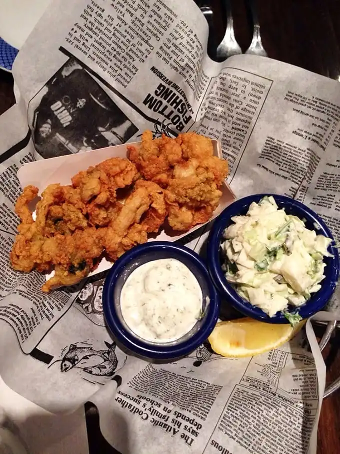 Golden-fried clams nestled on newspaper—the way Neptune intended them to be served—with coleslaw standing by like a refreshing palate lifeguard.