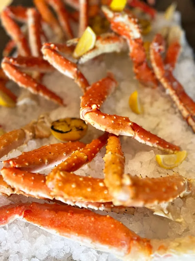 Snow crab legs arranged like a treasure map to deliciousness. These aren't those skinny imposters—these are the real deal, meaty specimens worth wrestling.