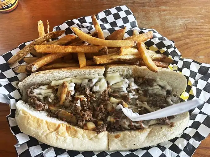 Behold the main event – thinly sliced ribeye, perfectly melted cheese, and a roll that somehow manages to contain all that glory. Napkins required, not optional.