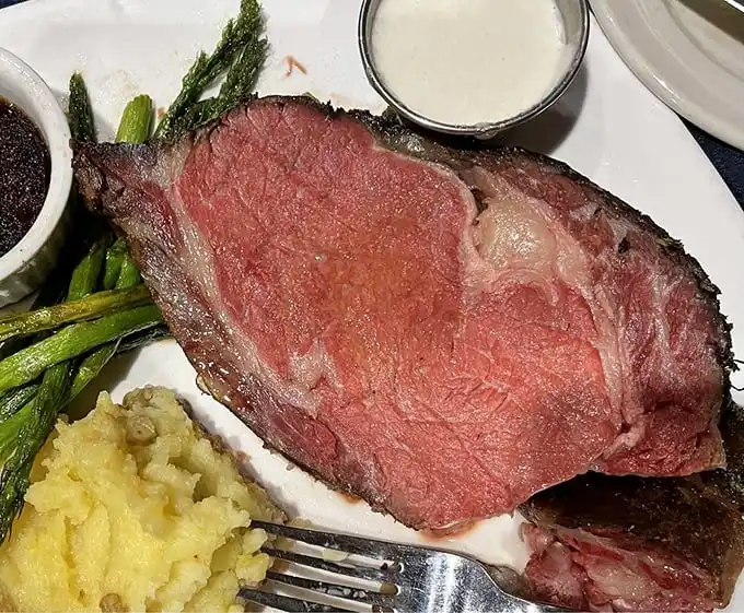 This isn't just prime rib—it's a masterclass in patience. That perfect pink center has been slow-roasted to the point where your knife practically becomes optional.