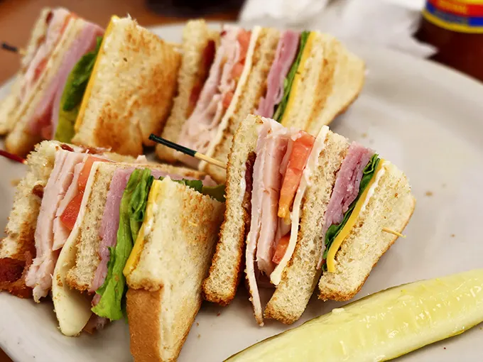 Club sandwich architecture that would make Frank Lloyd Wright jealous. Perfect stratification of meat, cheese, and veggies—the sandwich equivalent of a standing ovation.