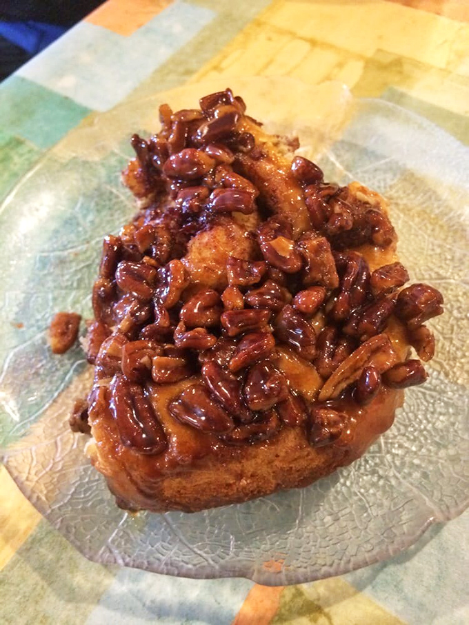 Behold the sticky bun in its natural habitat—glistening with caramel, studded with pecans, and absolutely no regard for your diet plans.
