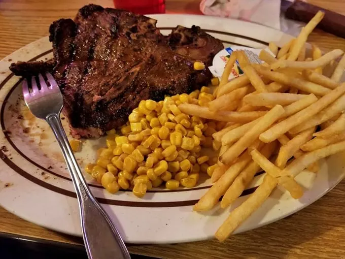 This isn't just a steak; it's a landscape of flavor with golden corn fields and french fry forests surrounding a mountain of perfectly charred beef.