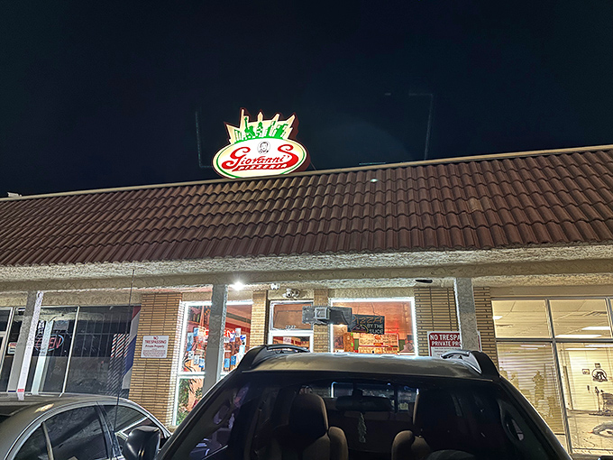 Giovanni's neon sign glows with promise in the night – like a lighthouse guiding hungry souls to pizza salvation.