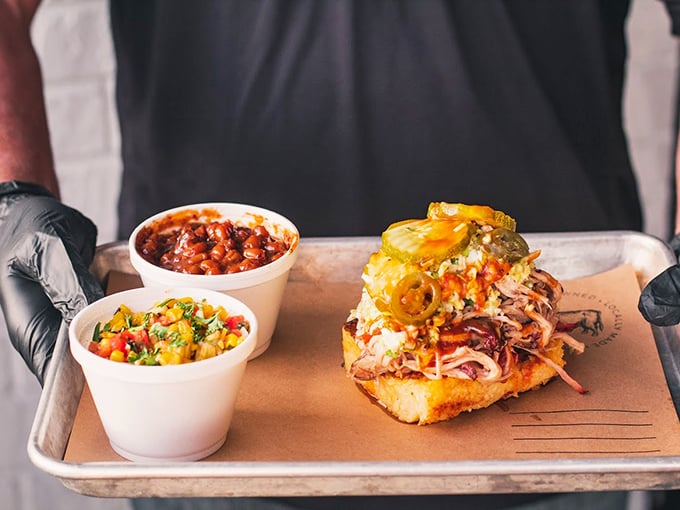 This isn't just a sandwich; it's an architectural marvel of pulled pork, slaw, and jalapeños that requires both hands and possibly a bib.