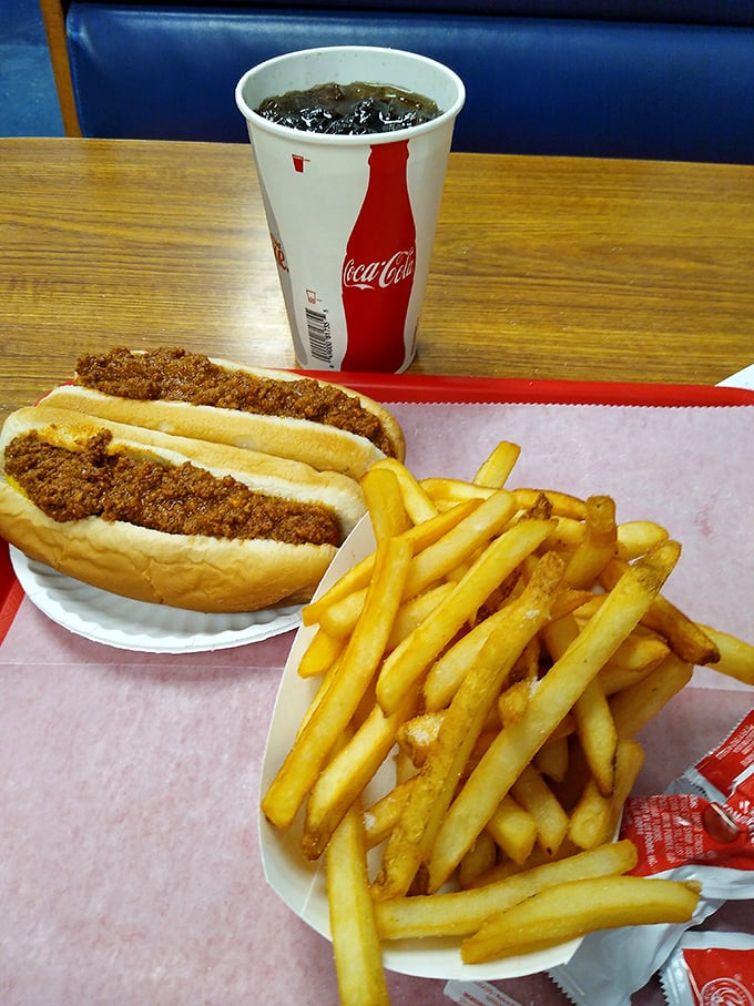The classic combo that's launched a thousand road trips—a Texas Hot Dog with a side of golden fries and an ice-cold Coca-Cola. Happiness on a paper plate.