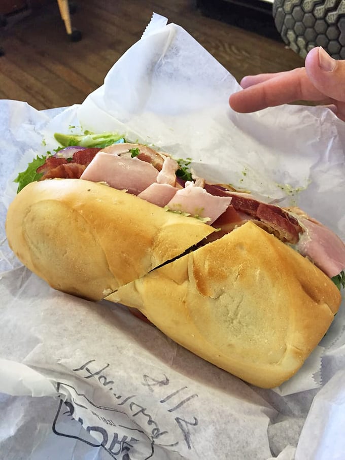 Behold the French roll masterpiece—layers of ham and fresh vegetables creating what might be the most photogenic lunch on Highway 1.