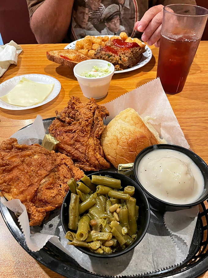 This isn't just a meal; it's edible architecture—a masterpiece of crispy chicken, tender green beans, and that roll standing guard.