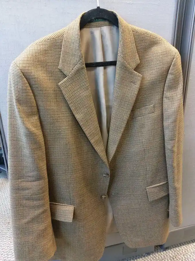 This houndstooth blazer isn't just clothing—it's a time machine to an era when people dressed for airplane flights and martini lunches.