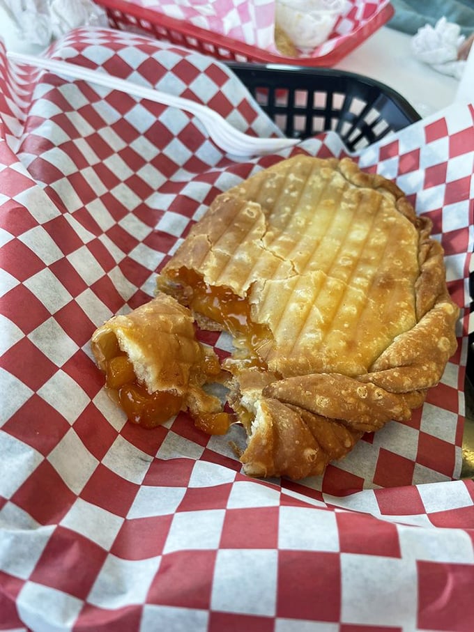 The peach pie's golden exterior gives way to a luscious filling that practically sings Southern hymns. That bite mark tells the whole story.
