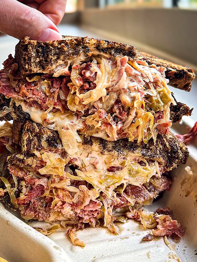 This isn't Instagram food—it's the real deal. Thick slices of ruby-red corned beef playing perfectly with Swiss and kraut in each bite.