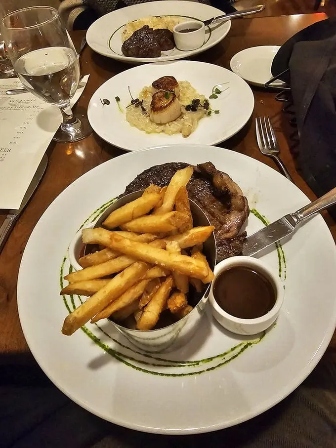 A triumvirate of deliciousness—steak with golden fries, scallops nestled on creamy risotto, and another cut waiting in the background. Decisions, decisions.