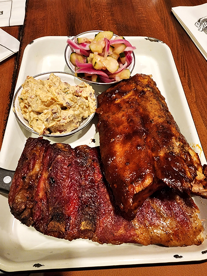 BBQ artistry on full display: two styles of ribs flanking homemade potato salad and pickled vegetables—a plate that makes vegetarians question their life choices.