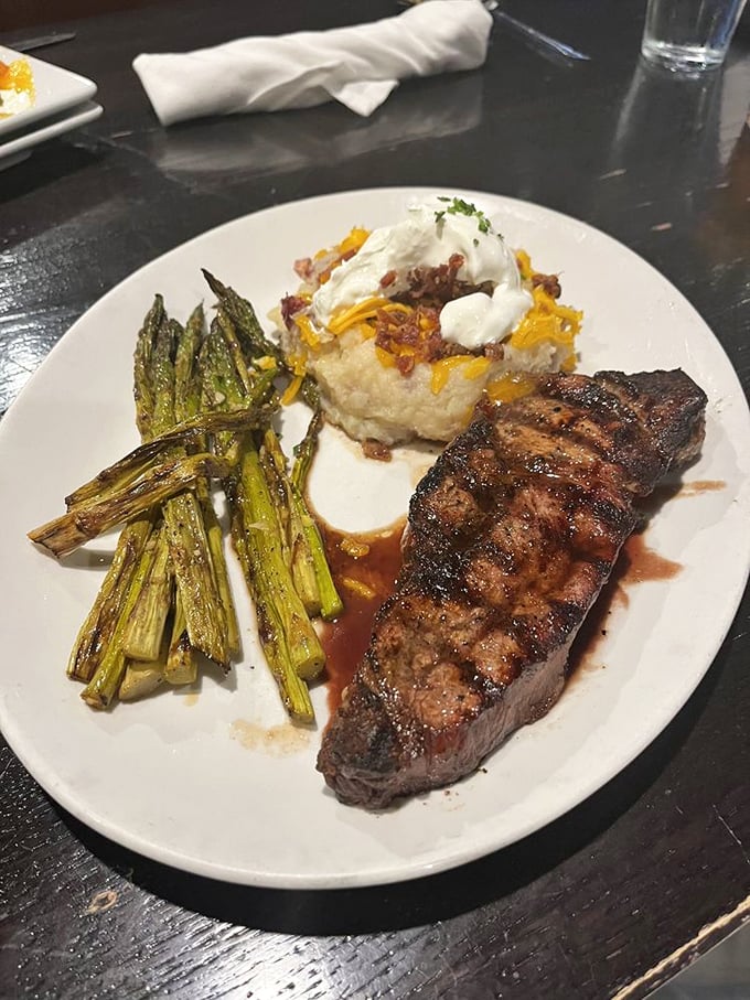 This plate is the holy trinity of steakhouse perfection—beautifully seared beef, grilled asparagus that still has dignity, and potatoes that didn't die in vain.