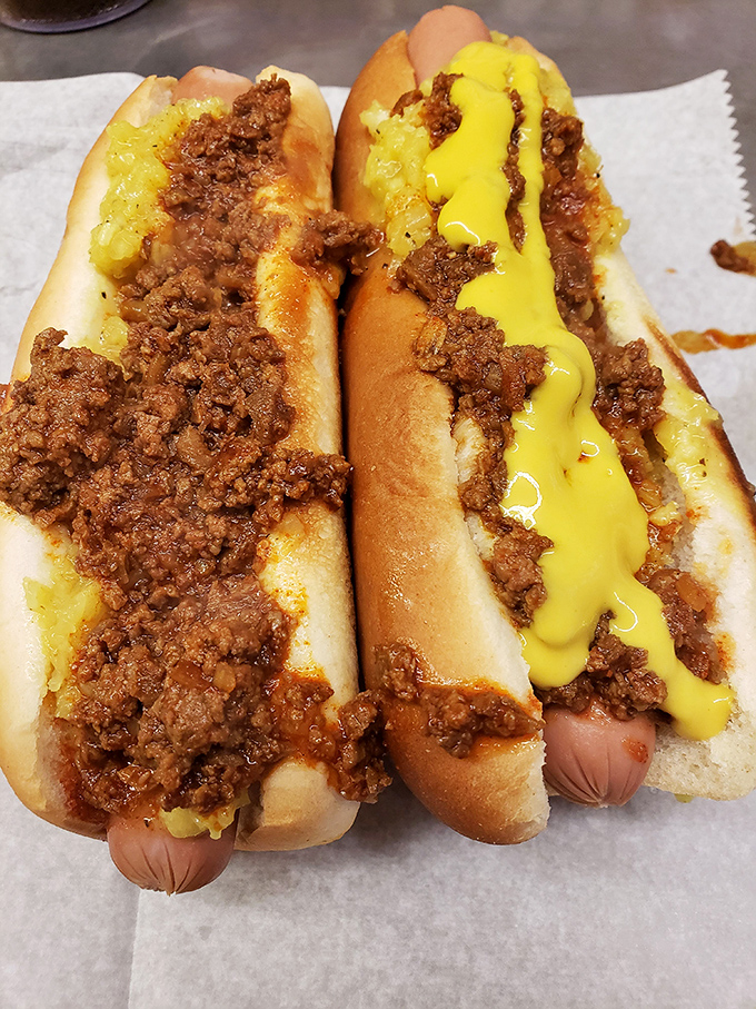 Two chili dogs with mustard—the yellow river of tangy goodness cutting through that famous meaty chili like sunshine after a storm.