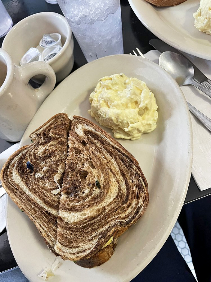 Marble rye toasted to perfection, paired with creamy potato salad that looks like it came straight from a church potluck championship—comfort food that hugs your soul.