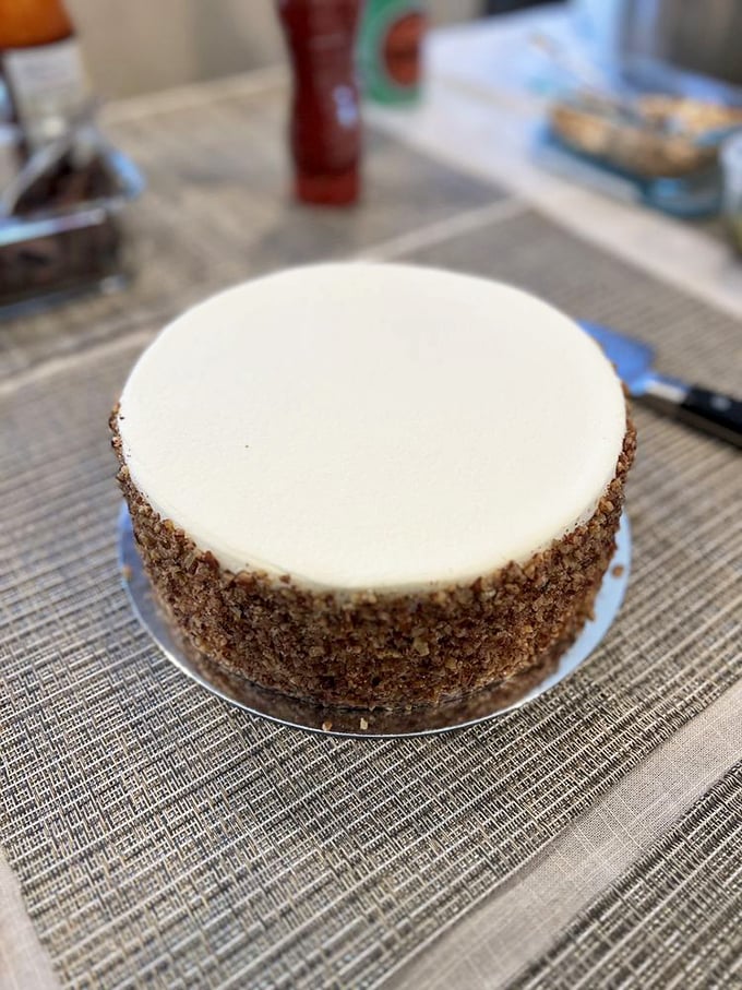 Behold the complete carrot cake in all its glory—a masterpiece of moist perfection ringed with toasted nuts that add just the right textural counterpoint.