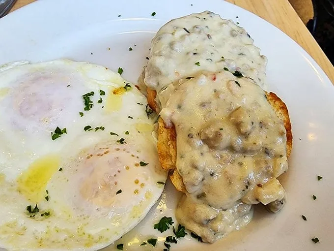 Southern comfort in its purest form—creamy gravy blankets a golden biscuit while perfectly cooked eggs stand by, ready for their moment of glory.