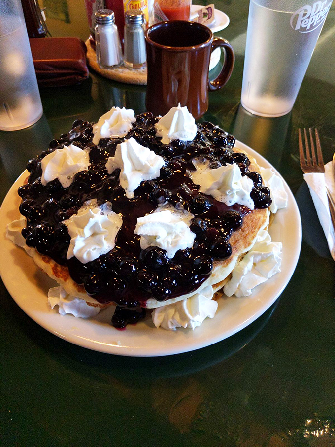 This isn't just a blueberry pancake—it's a monument to excess, where whipped cream islands float in a sea of blueberry bliss. Diet starts tomorrow!