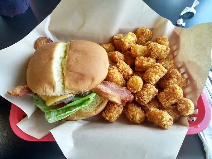 This isn't just a burger – it's a masterclass in comfort, served with a side of crispy tater tots that whisper, "Diet? What diet?"