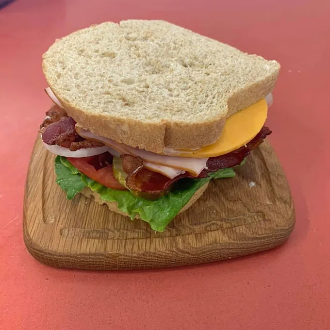 Layer upon glorious layer – this club sandwich isn't trying to impress anyone, which is precisely why it's so impressive.