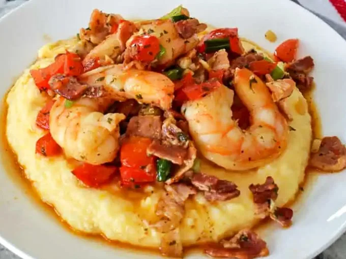 A Southern classic reimagined—these grits cradle plump shrimp and bacon with the tenderness of a lullaby. Comfort food that graduated with honors.