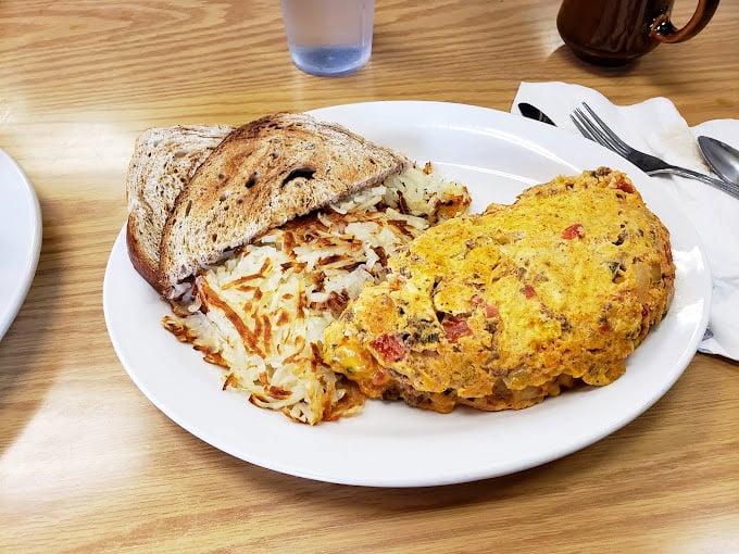 The holy trinity of morning perfection: crispy hash browns, over-easy eggs, and toast that knows its supporting role but plays it perfectly.