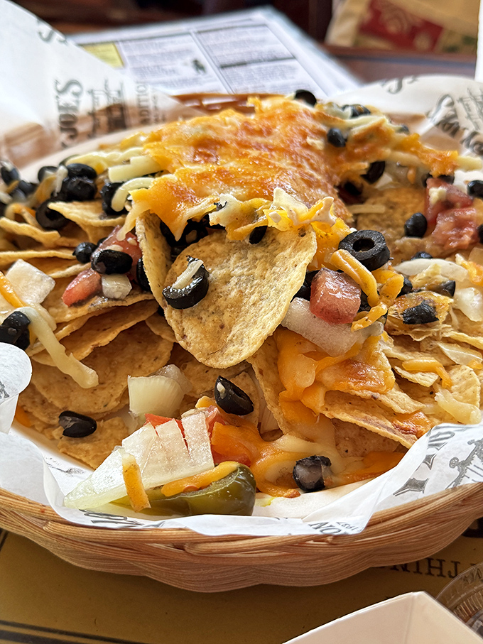 These nachos aren't just a snack—they're an architectural achievement of cheese, olives, and jalapeños that would make Frank Gehry jealous.