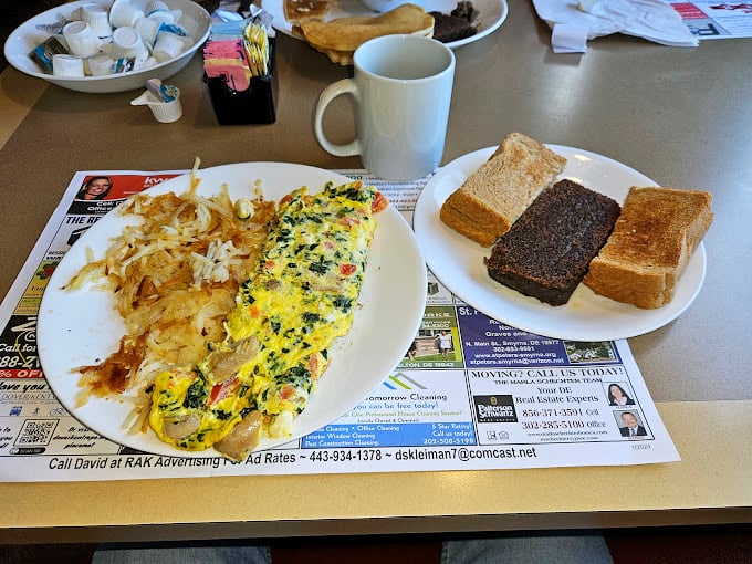 This isn't just an omelet—it's a technicolor dream of vegetables and cheese, with home fries that deserve their own fan club.