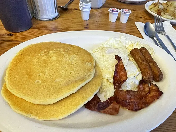 The holy trinity of breakfast perfection: golden pancakes with the ideal fluff factor, eggs with just-right runniness, and bacon that's achieved crispy nirvana.