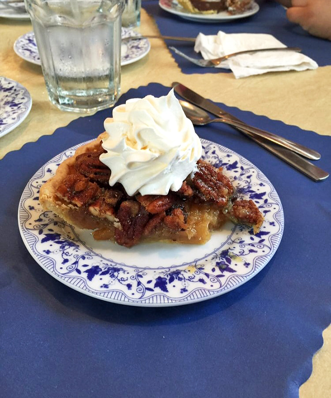 Pecan pie perfection with a cloud of whipped cream—this isn't just dessert, it's an edible work of art that would make Georgia pecan farmers weep with joy.