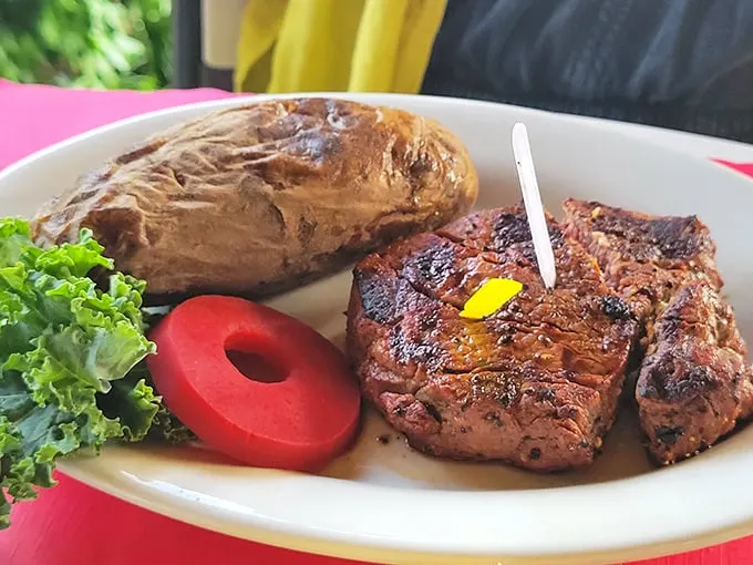 A filet that demands your attention, accompanied by a baked potato that's practically begging to be smothered in toppings.
