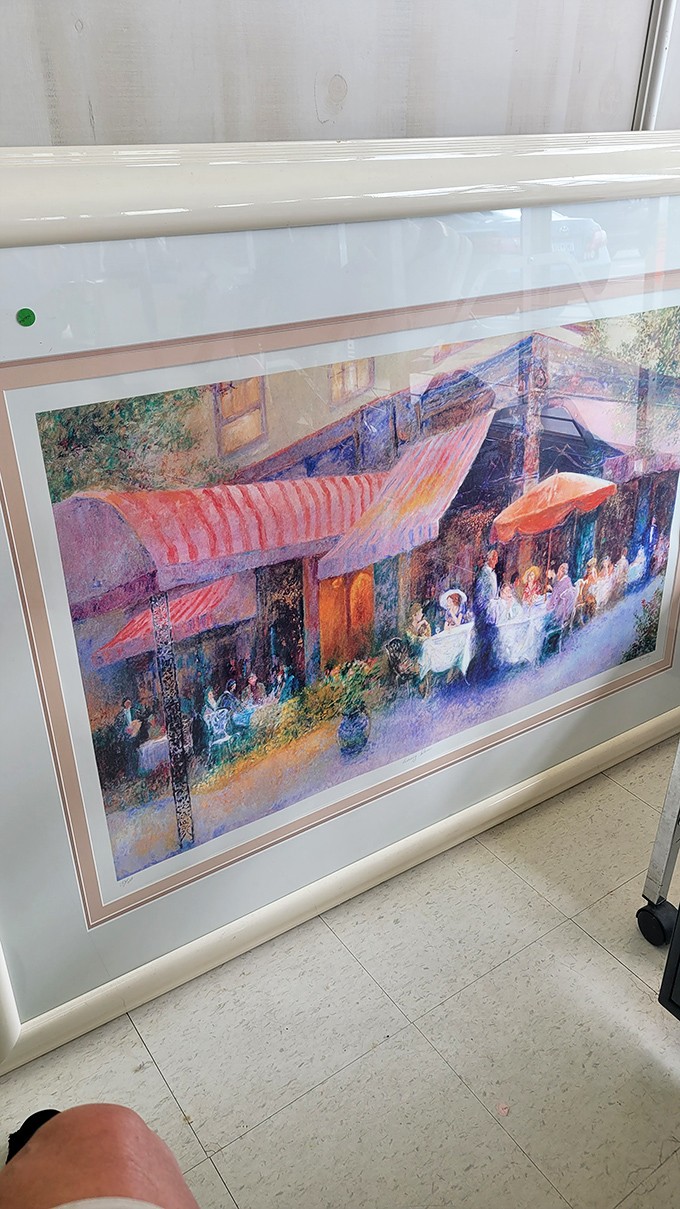 Fine art finds its second act on thrift store walls. This café scene might have graced someone's dining room before finding its way here.