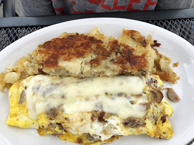 Breakfast architecture at its finest—golden eggs supporting a perfect cheese roof. Those home fries deserve their own fan club.