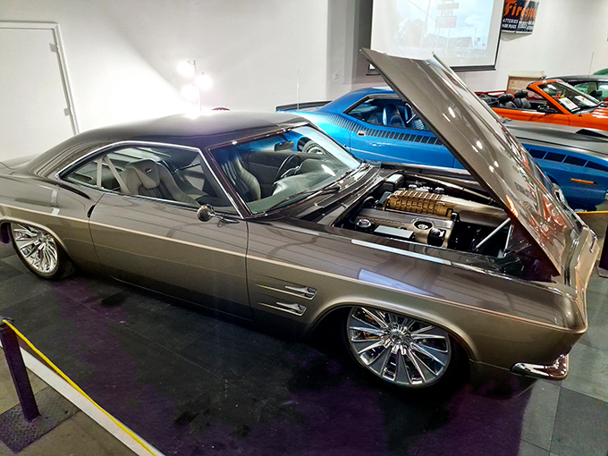 This 1965 Chevrolet Impala's hood is up, revealing the mechanical heart that powered America's love affair with the open highway.
